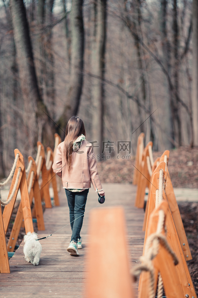 带着白色小狗的小女孩。高清摄影大图-千库网