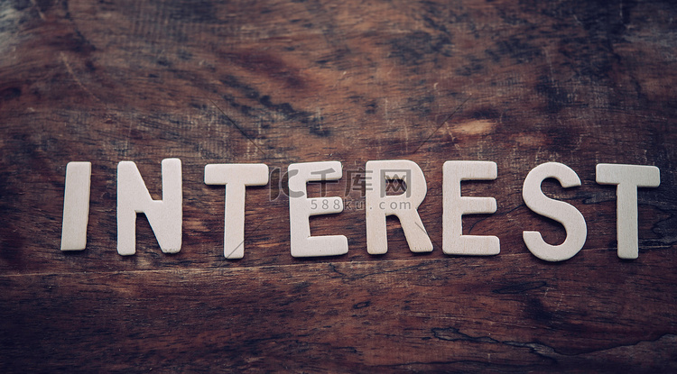 “INTEREST”这个词是由放在木板上的木字排列而成高清摄影大图-千库网