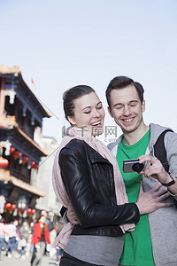 年轻夫妇观光，看着数码相机。高清摄影大图-千库网