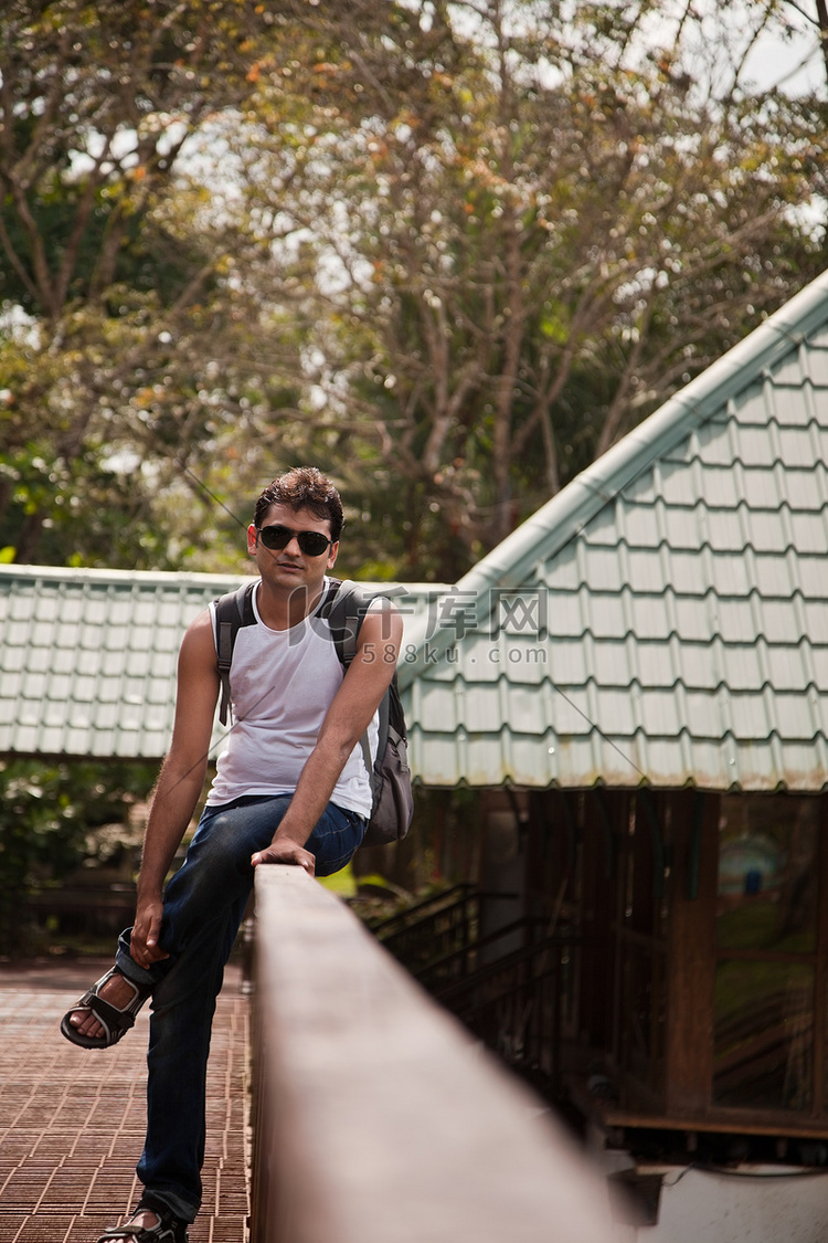 坐在房子栏杆上的快乐印度男人高清摄影大图-千库网