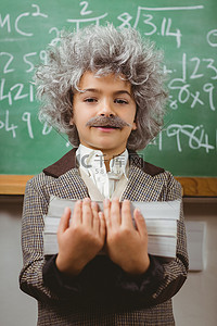 小爱因斯坦在黑板前拿着书高清摄影大图-千库网