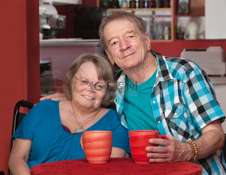 微笑的高级男性和女性在餐桌上高清摄影大图-千库网