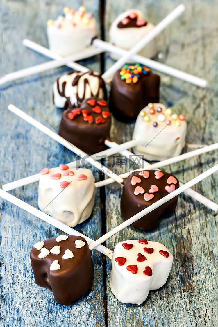 许多形状为心形的 Cake Pops 躺在旧的蓝色木背上高清摄影大图-千库网