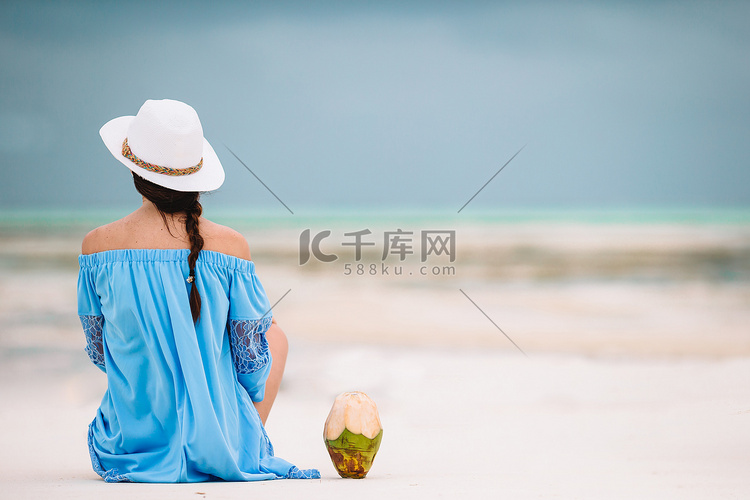 年轻女子在热带度假期间喝椰奶高清摄影大图-千库网