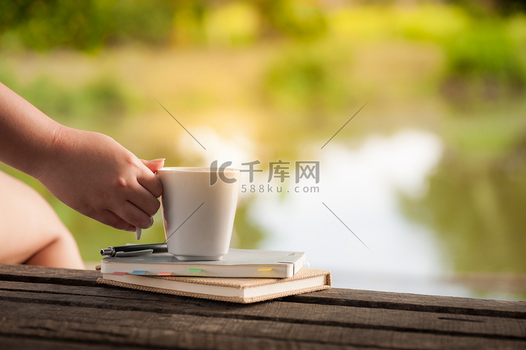 有笔记本的咖啡杯在土气木桌上高清摄影大图-千库网