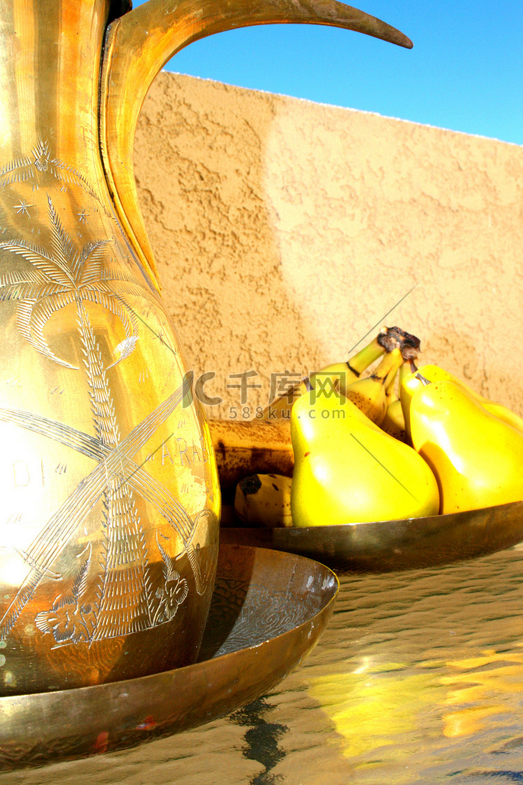 桌上的黄铜醒酒器和水果高清摄影大图-千库网