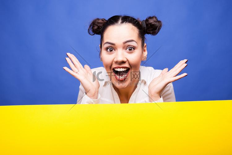 在一副黄色横幅旁边的惊奇的妇女高清摄影大图 千库网