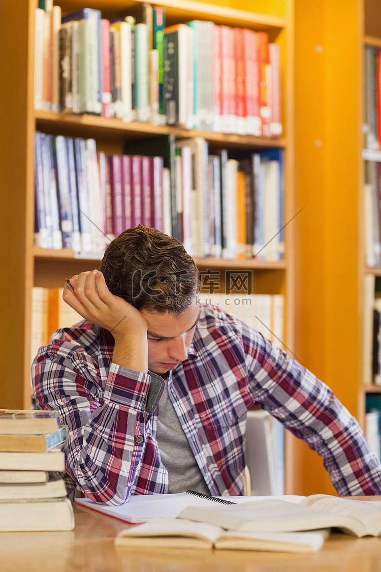 学习他的书的英俊的疲乏的学生高清摄影大图-千库网