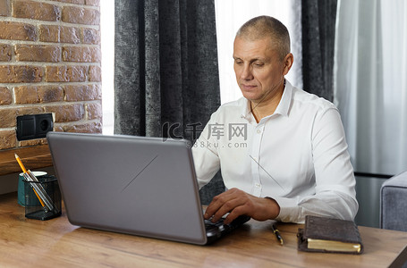 商人，中年，在家里用笔记本电脑工作。高清摄影大图-千库网
