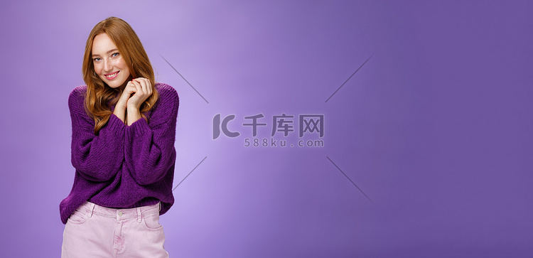 可爱而温柔的红发女友浪漫地瞥了一眼,调情和咯咯地笑着,手牵着手靠近肩膀,微笑着,在紫色的墙上害羞而娇媚地看着镜头高清摄影大图 千库网