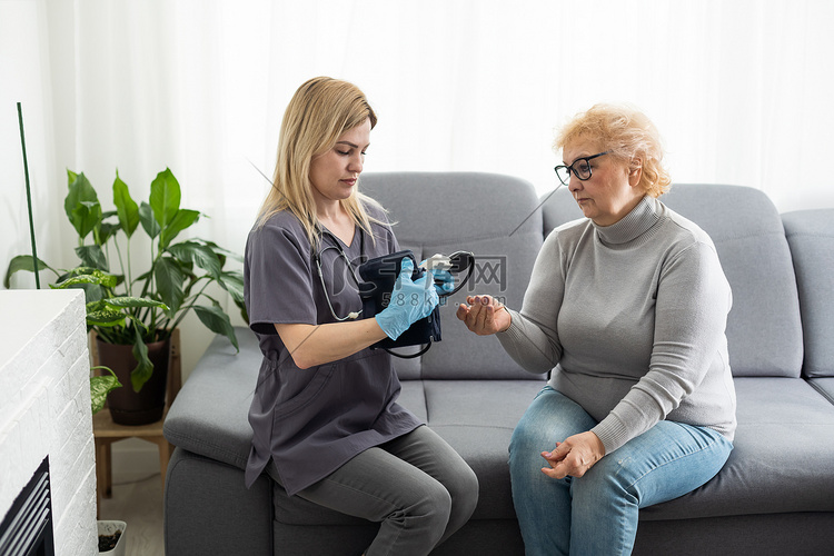 家访期间的健康访问员和一名老年妇女高清摄影大图-千库网