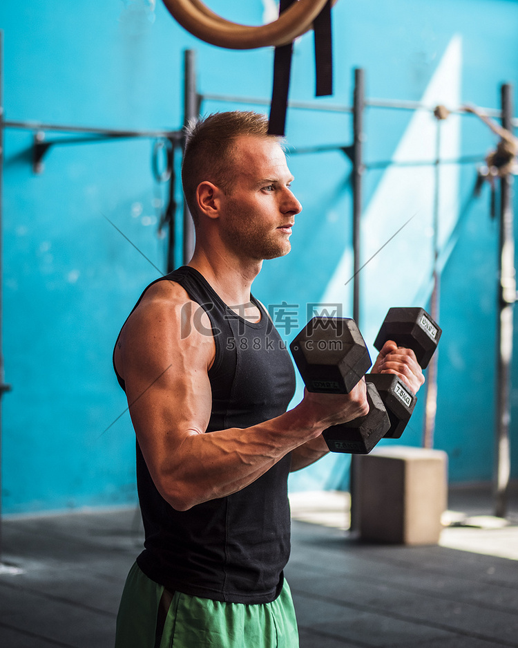 年轻人训练二头肌举哑铃高清摄影大图-千库网