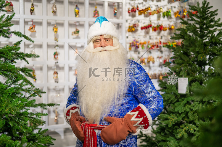 俄罗斯圣诞老人为店内的圣诞树挑选装饰品。高清摄影大图-千库网