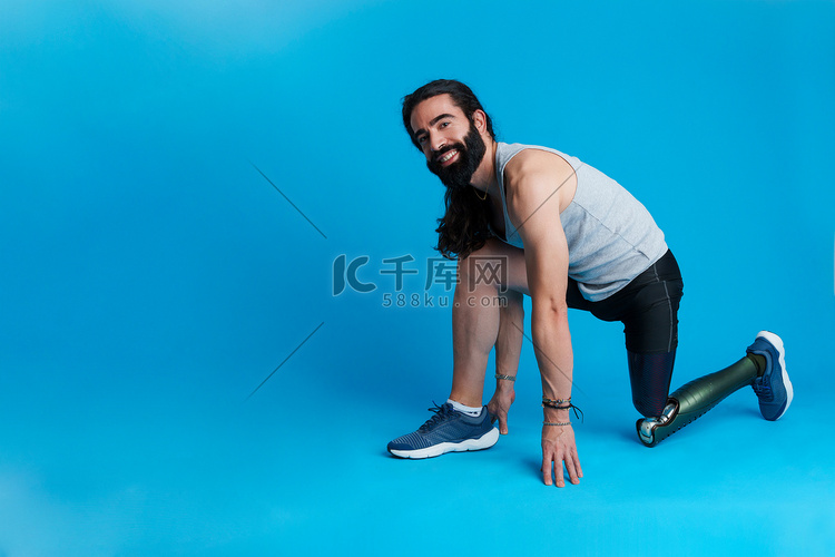 带腿假肢的笑脸男子处于短跑位置高清摄影大图-千库网