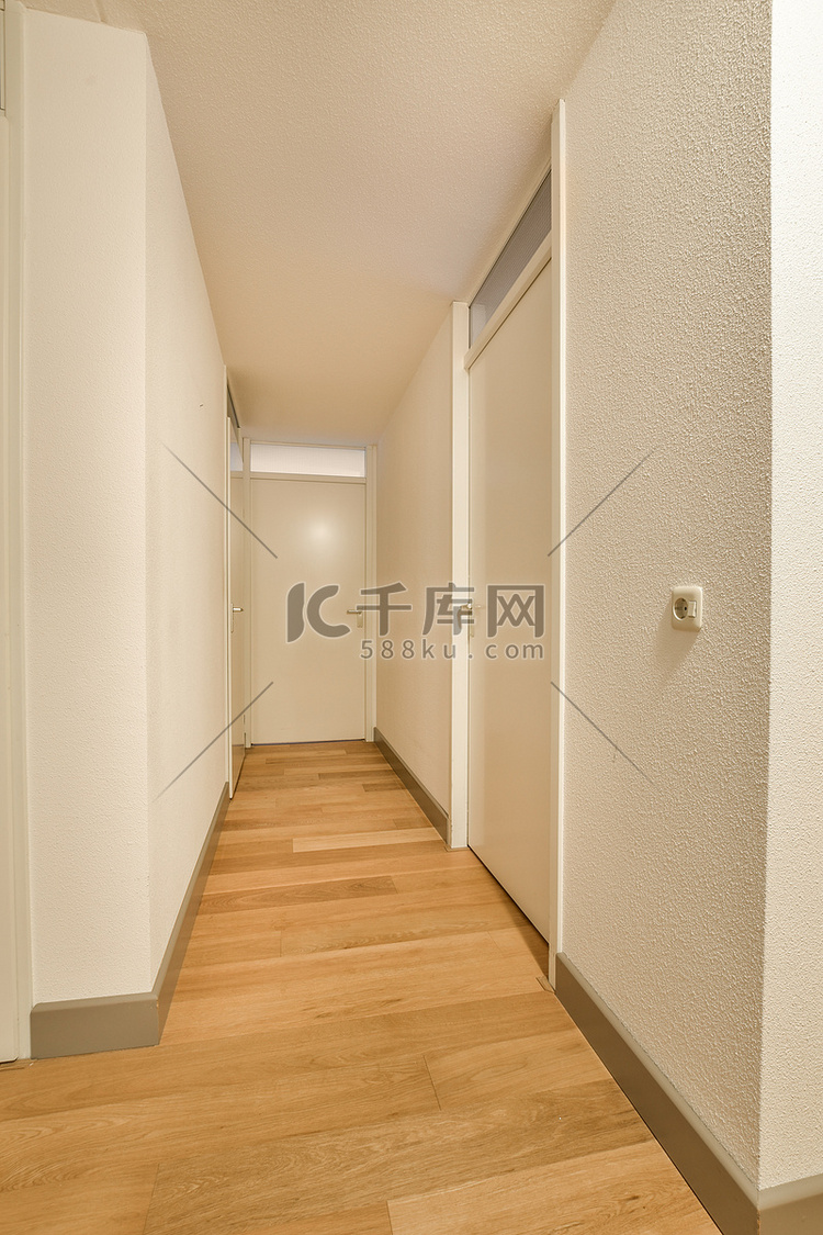 铺有木地板、白色墙壁和门的走廊高清摄影大图-千库网