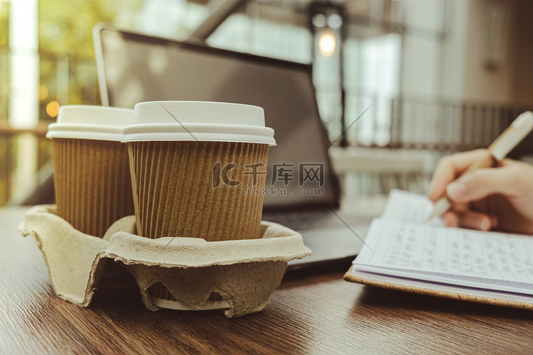 面目全非的年轻女子在购物中心美食广场的木桌旁学习。高清摄影大图-千库网