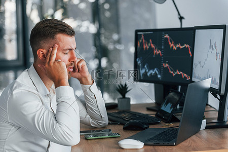 穿着正装的年轻商人在办公室里有多个屏幕高清摄影大图-千库网