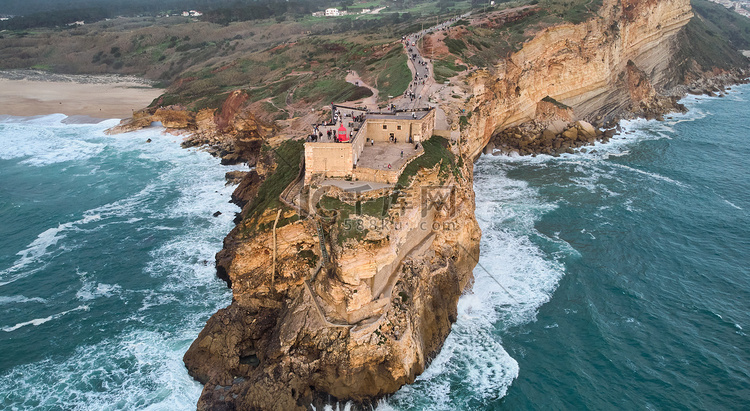 葡萄牙纳扎雷镇大西洋沿岸悬崖上的一座旧灯塔和一座堡垒的鸟瞰图。高清摄影大图-千库网