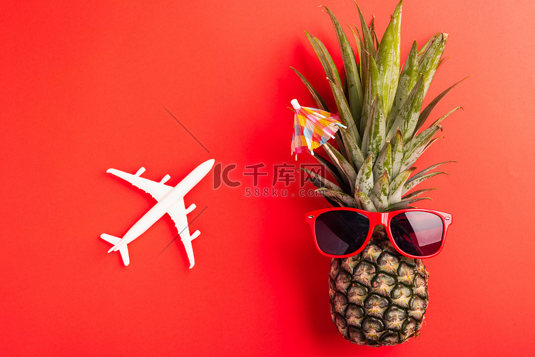 新鲜菠萝戴红色墨镜配飞机模型高清摄影大图-千库网