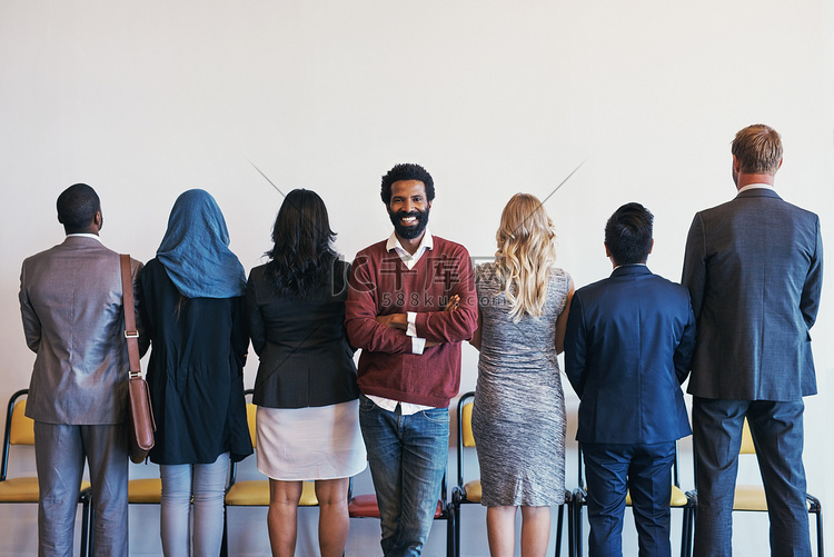 一位开朗的年轻商人在等待面试时排队等候的肖像，其余候选人背对着镜头高清摄影大图-千库网