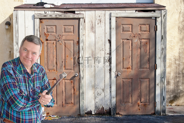 带锤子的成熟 DIYer 准备拆除旧棚子高清摄影大图-千库网