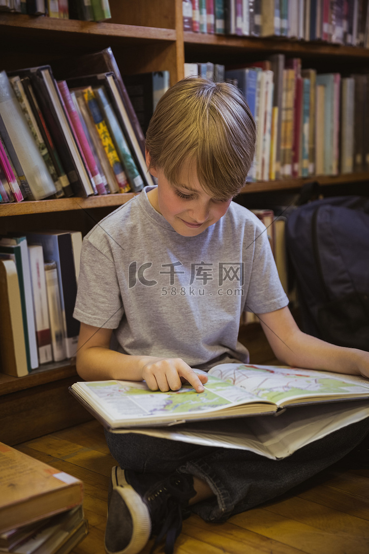 在图书馆地板上看书的小男孩高清摄影大图-千库网