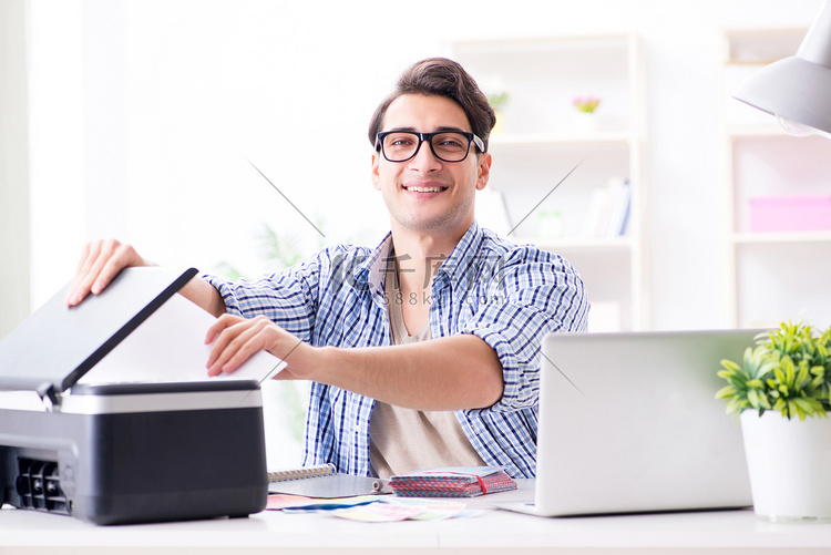 在办公室复印机工作的年轻男员工高清摄影大图-千库网