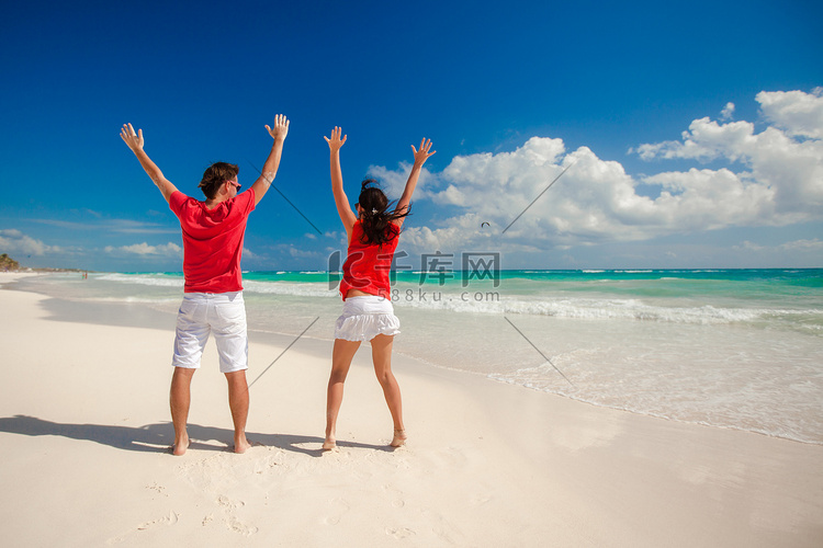 站在白色沙滩上的年轻夫妇张开双臂的背影高清摄影大图-千库网