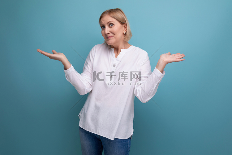 工作室背景中皮肤均匀、穿着整齐的金发迷人成熟女性高清摄影大图-千库网