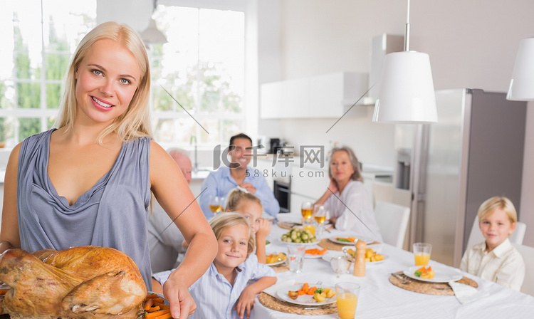 展示烤火鸡的金发女人高清摄影大图-千库网