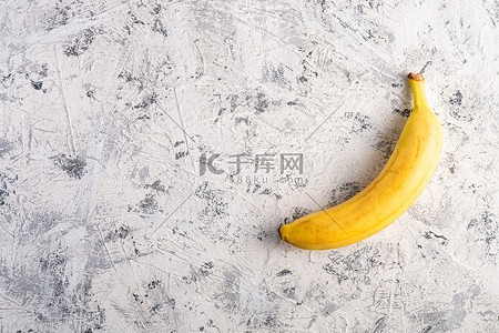白色带纹理的背景上的单个香蕉果实高清摄影大图-千库网