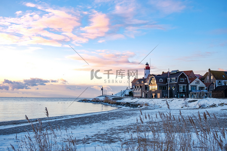 Urk 荷兰灯塔在冬季与白雪覆盖的海岸线，Urk 视图在灯塔雪景冬季天气在荷兰高清摄影大图-千库网