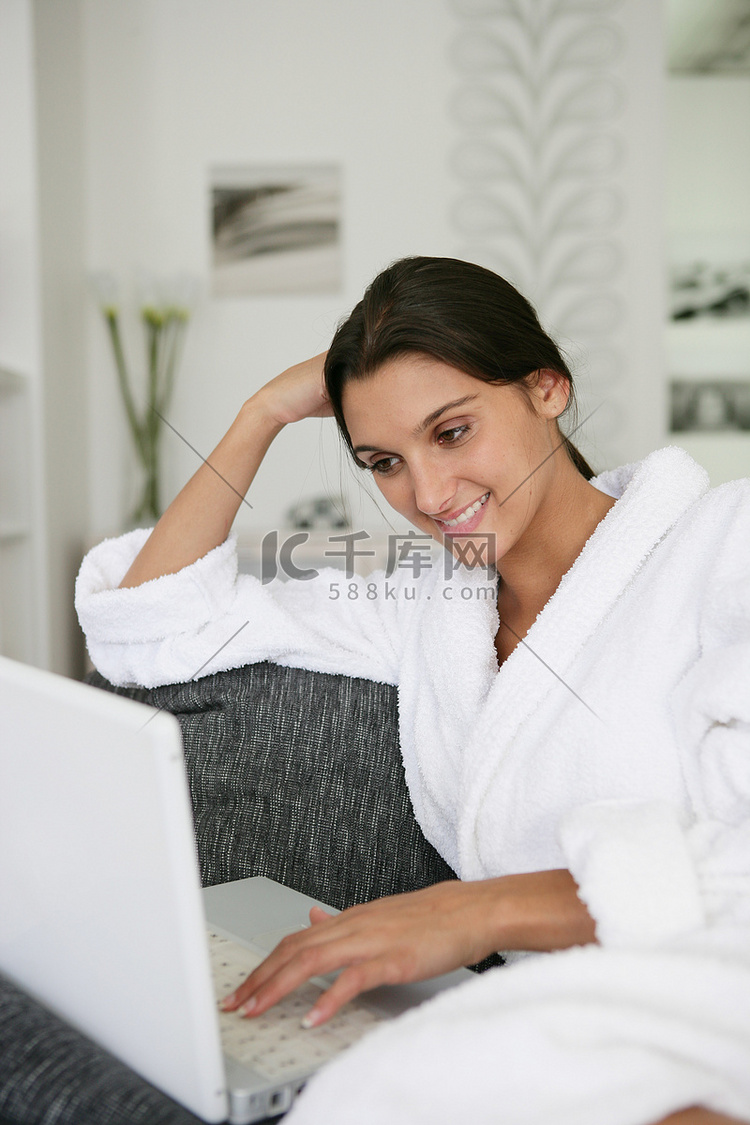 穿着浴袍的黑发女郎使用笔记本电脑高清摄影大图 千库网