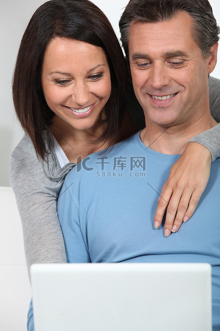 一对四十多岁的人看起来对电脑很满意高清摄影大图-千库网