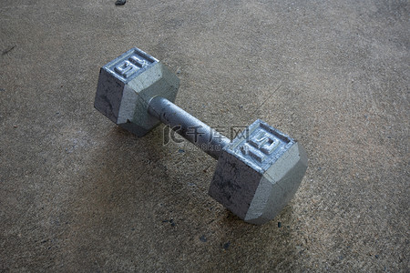 混凝土上的银色 15 磅哑铃高清摄影大图-千库网