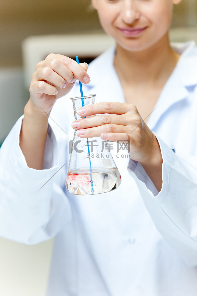 一位女科学家在 erlenmeyer 中摇晃液体的肖像高清摄影大图-千库网