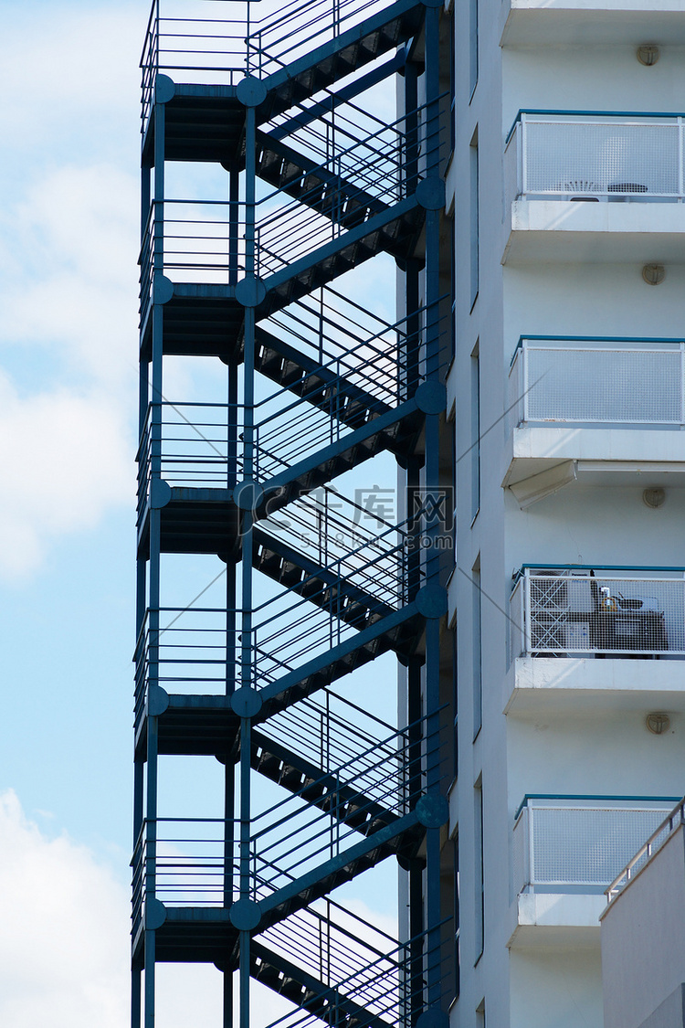 天空背景下住宅楼墙壁上的金属防火梯高清摄影大图-千库网