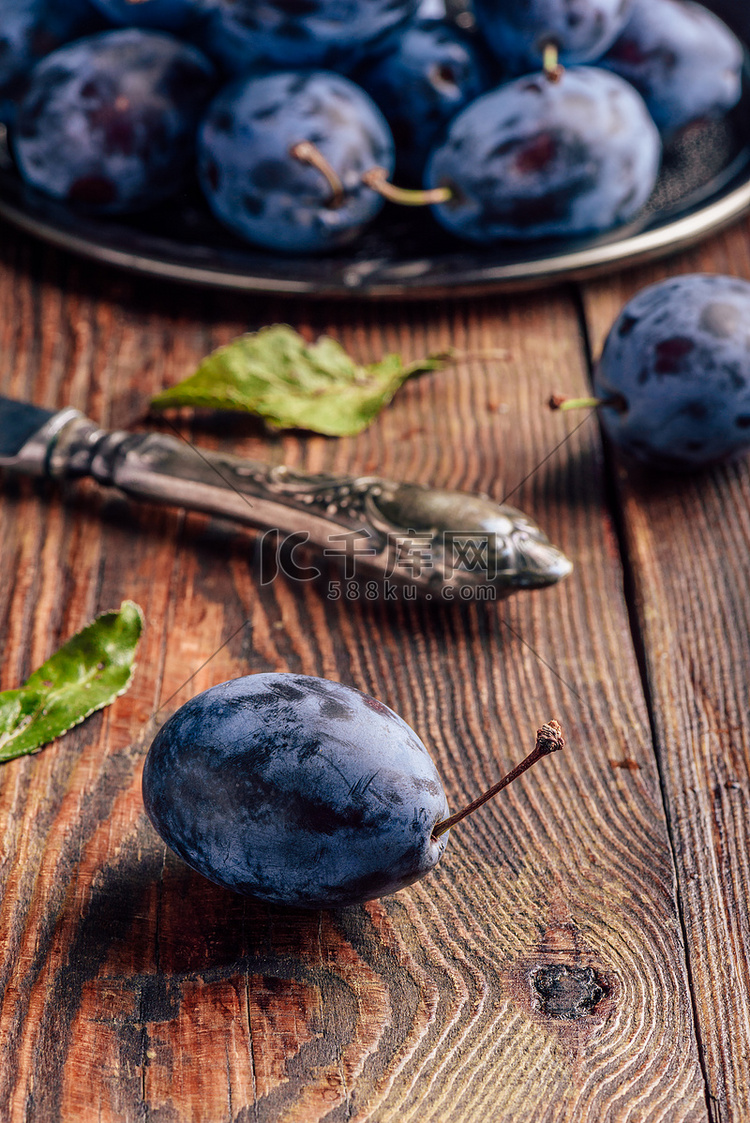 有叶子和刀的成熟李子高清摄影大图-千库网