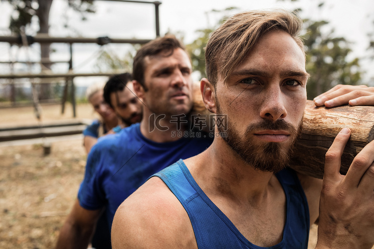 人们在新兵训练营期间携带沉重的木头高清摄影大图-千库网