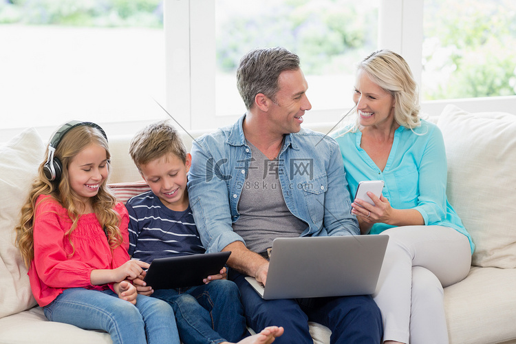 使用数字平板电脑、手机和笔记本电脑的父母和孩子高清摄影大图-千库网