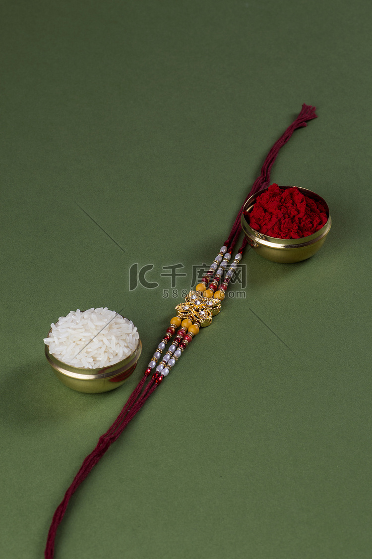 印度节日：Raksha Bandhan 背景与优雅的 Rakhi、米粒和 Kumkum。高清摄影大图-千库网