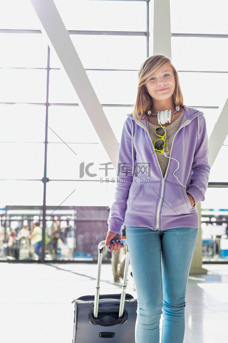 年轻少女在机场带着手提箱行走的画像高清摄影大图-千库网