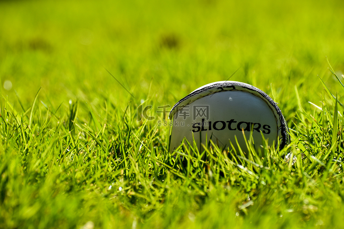 草地运动场上的爱尔兰曲棍球或 Camogie sliotar 球高清摄影大图-千库网