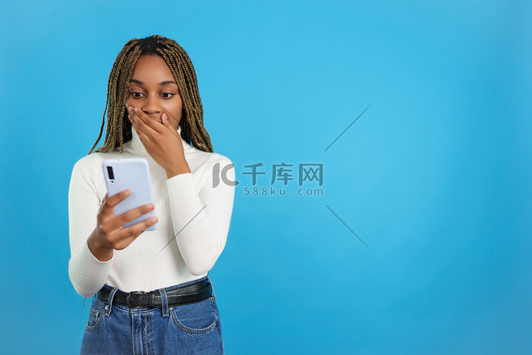 非洲女人看着手机，表情惊讶高清摄影大图-千库网