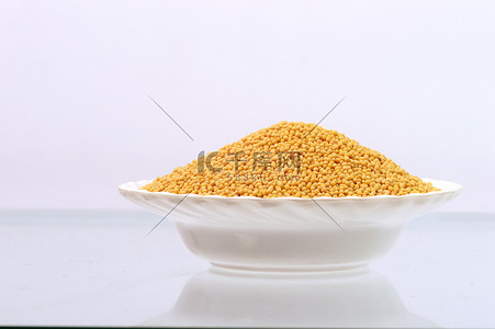 白色背景中分离的盘子中的黄芥末种子高清摄影大图-千库网