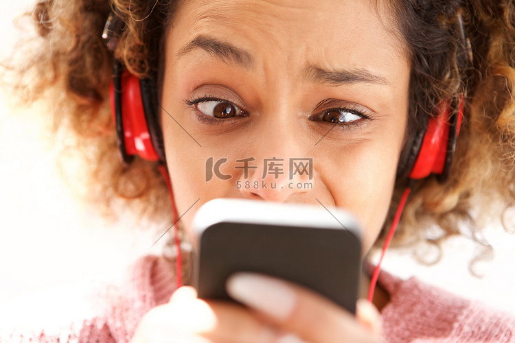 看手机时表情困惑的年轻非洲裔美国女性高清摄影大图-千库网