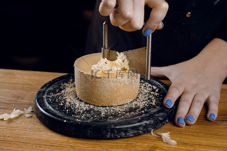 使用 girolle 刀剃掉 tete de moine 奶酪。高清摄影大图-千库网