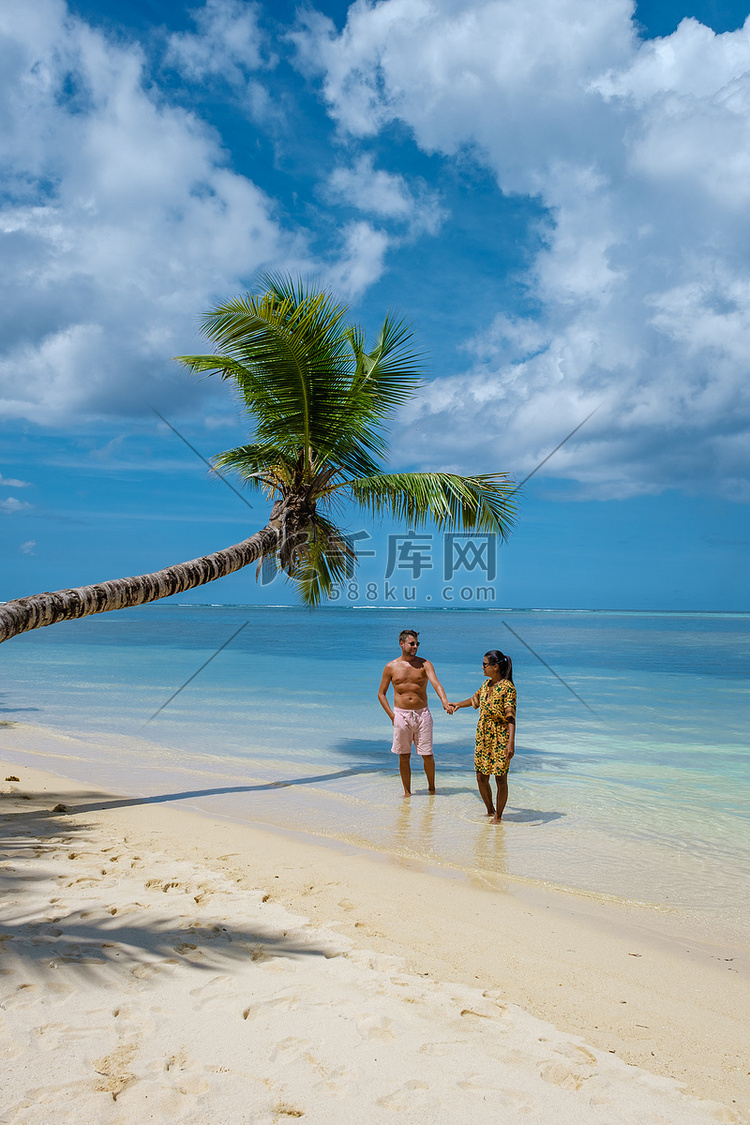 Mahe Seychelles，带棕榈树的热带海滩和 Mahe Seychelles Anse Royale 海滩的蓝色海洋，一对男女在塞舌尔 ...