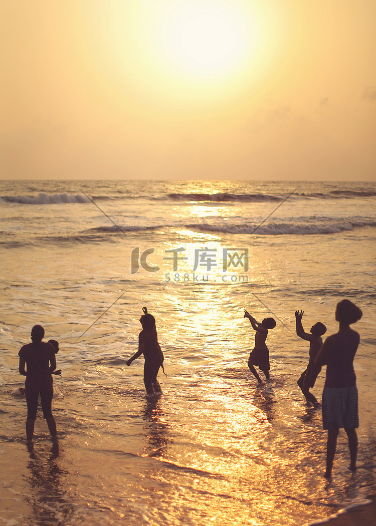 斯里兰卡卡卢特勒-2017 年 4 月 15 日：人们的轮廓，大部分是在金色夕阳的夕阳下在海边沙滩上玩耍的孩子。高清摄影大图-千库网