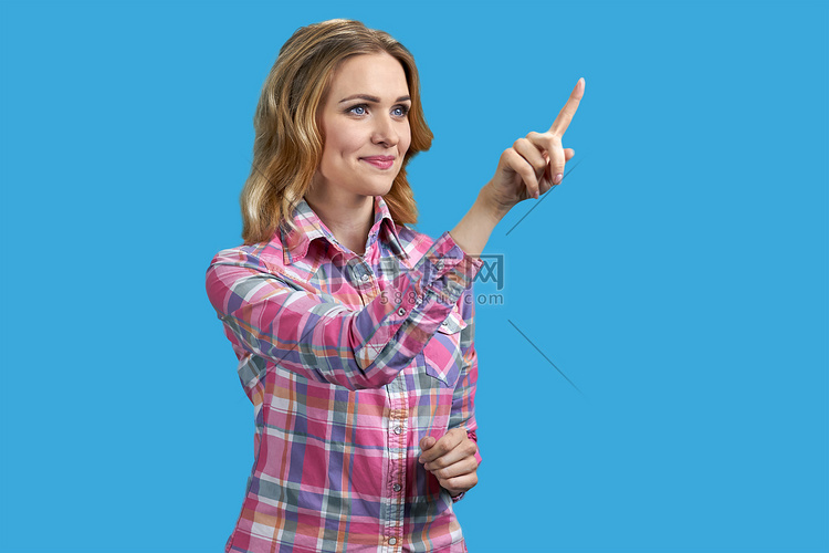 在彩色背景上使用虚拟屏幕的年轻女子。高清摄影大图-千库网